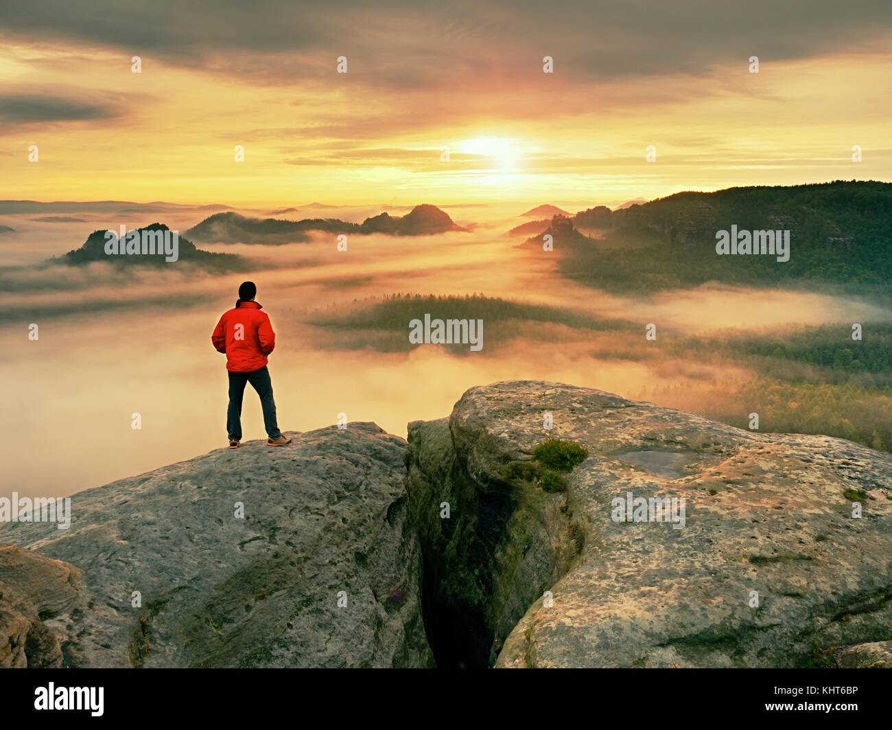 Hiker in black on the rocky peak. Wonderful daybreak in mountains ...