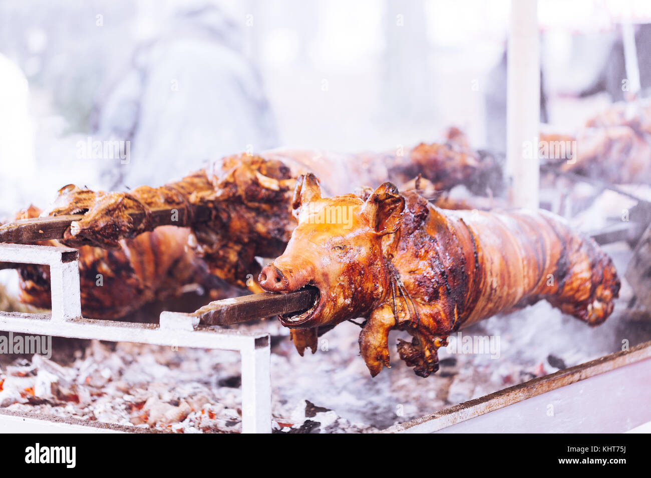 Traditionally suckling pig on a rotating spit with fire and smoke Stock ...