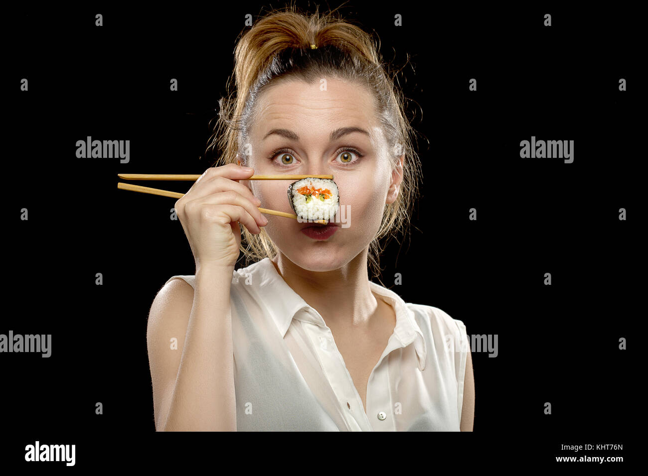 fun girl show snout with sushi roll on black background with copy space ...