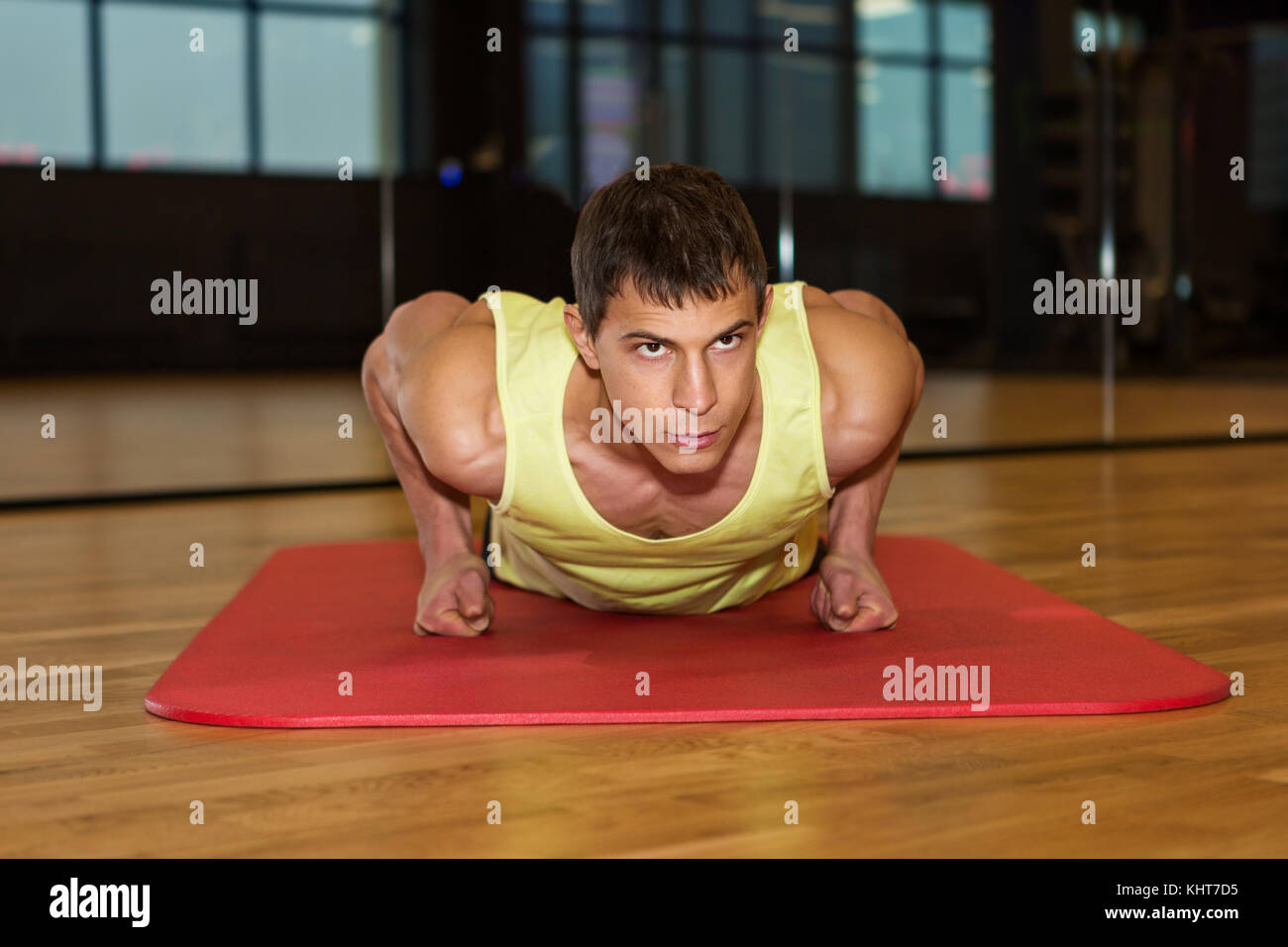 Young muscle man doing push ups in gym. Bodybuilder male working out in ...