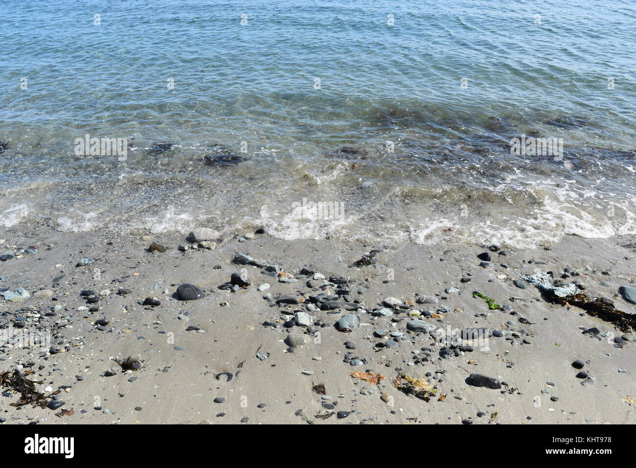 Pebble and sand beach with gentle waves. Newcastle, Northern Ireland ...