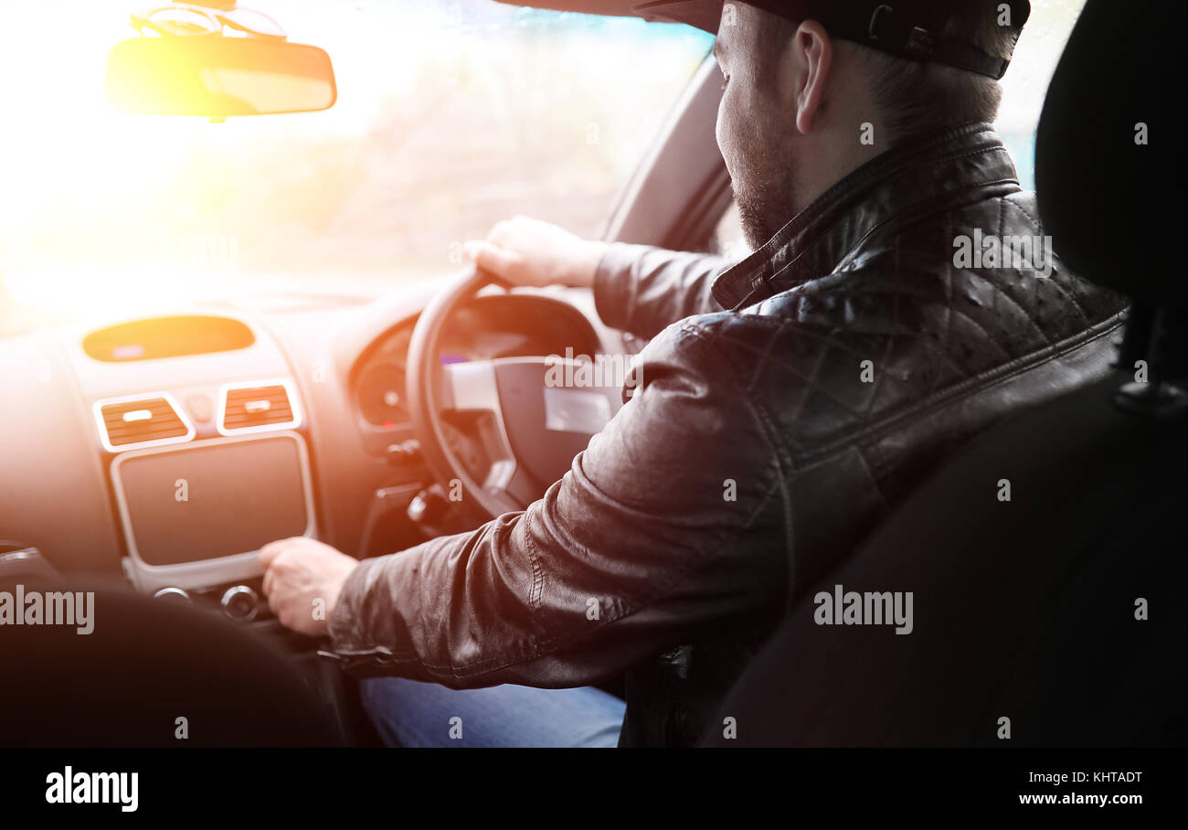 A man drives a car. The driver is driving by car along the road Stock ...