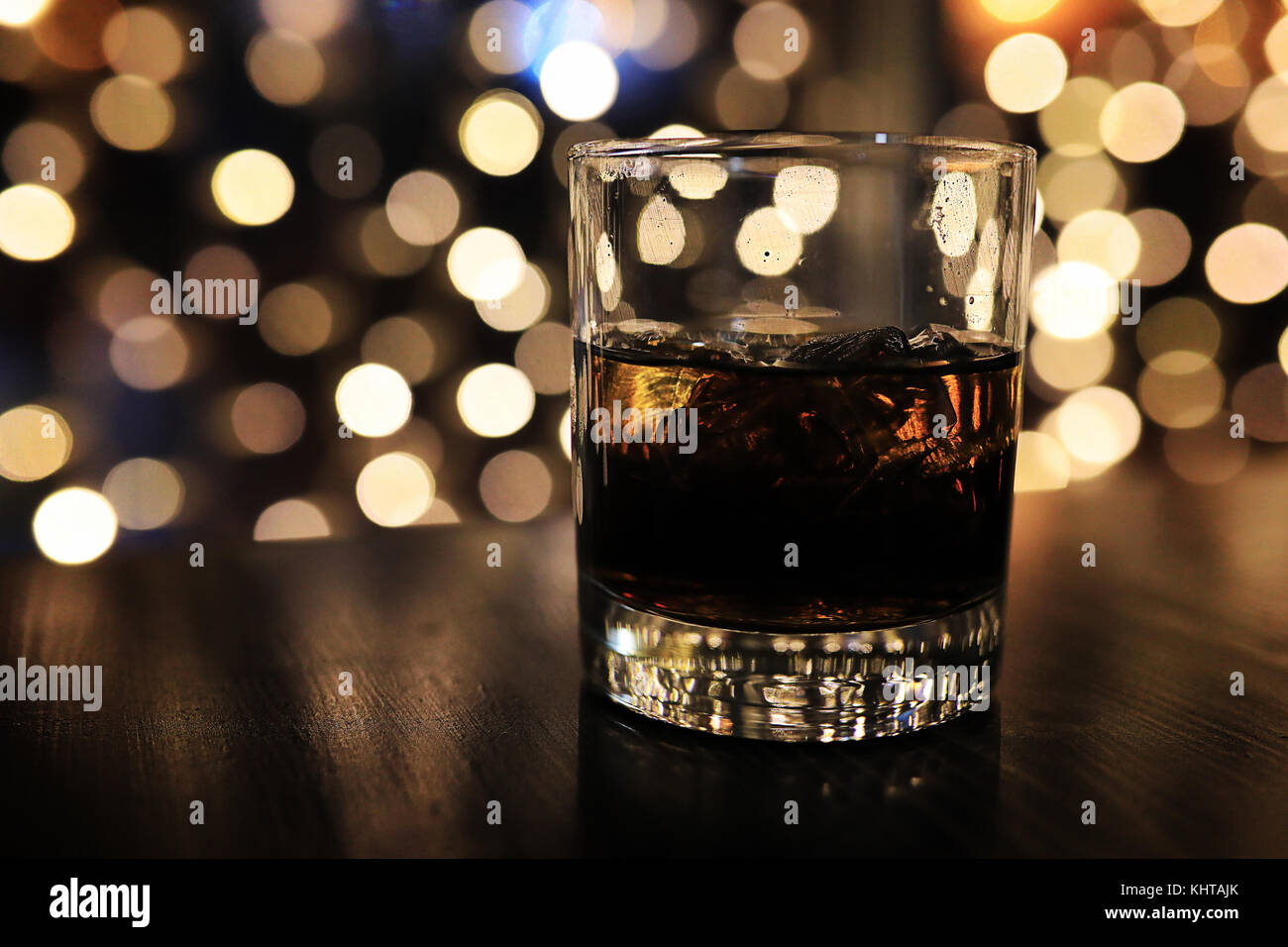 glass of alcohol with ice on blured background with circle bokeh Stock ...
