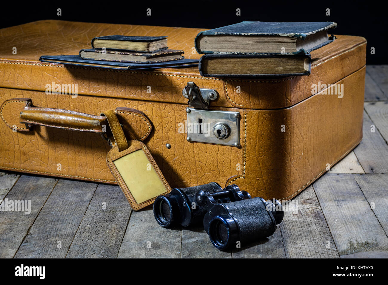 Old stylish suitcase. Old books in a suitcase. Suitcase on a wooden ...