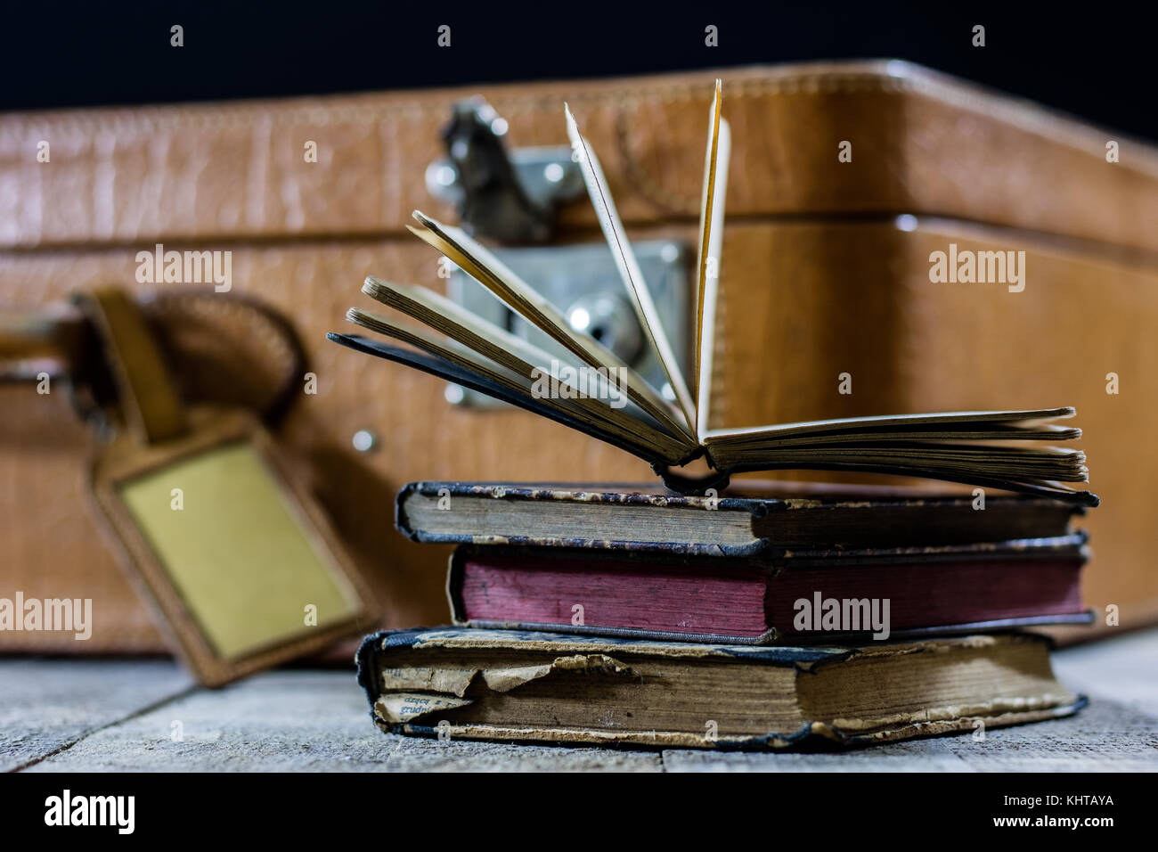 Old stylish suitcase. Old books in a suitcase. Suitcase on a wooden ...