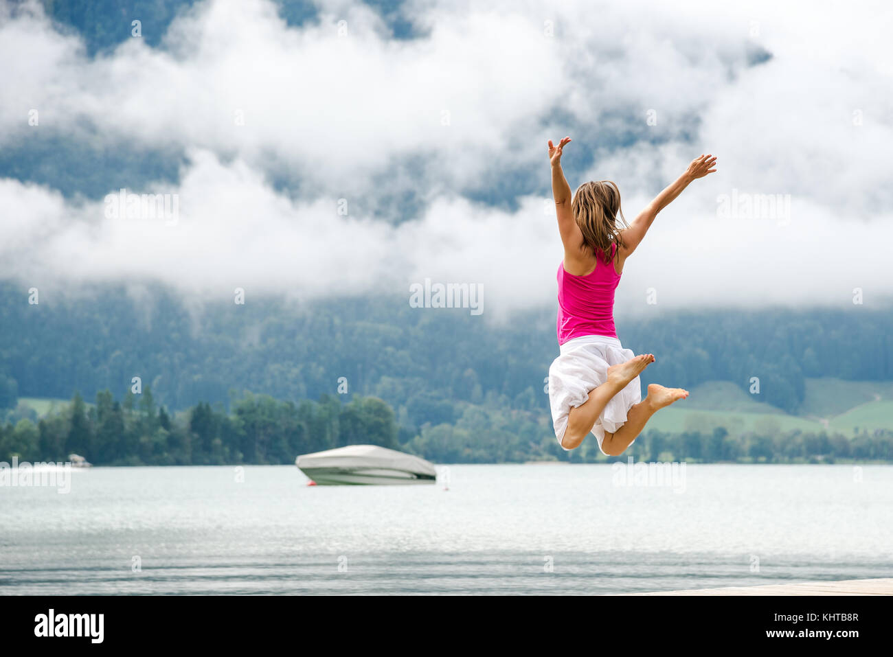 Woman jumping at the lake Stock Photo - Alamy