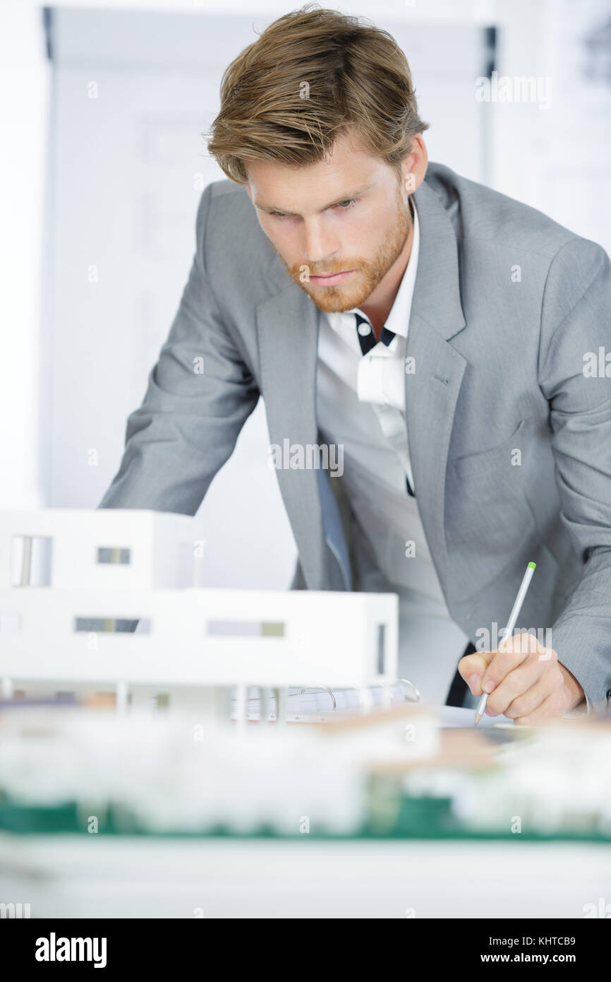 Architect looking at model and making notes Stock Photo - Alamy