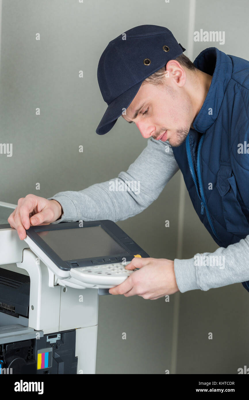 Technician working on photocopier Stock Photo - Alamy