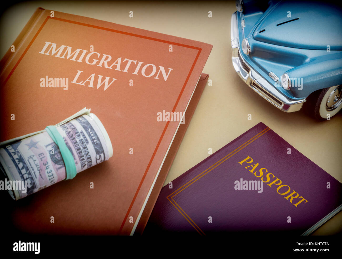Immigration law book next to a passport and blue miniature vehicle ...