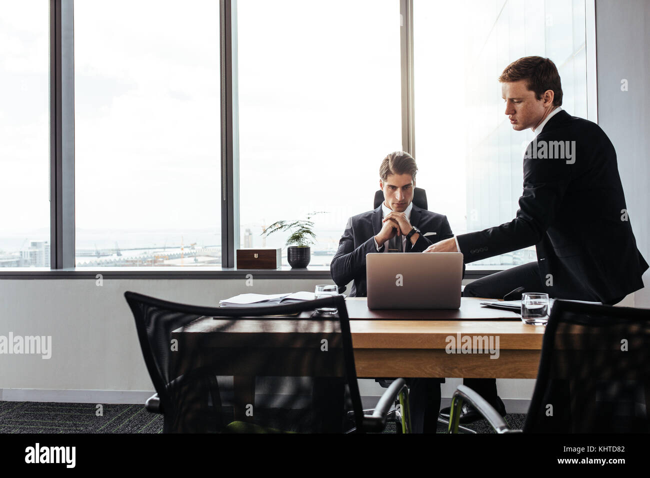 Two young corporate professionals working together at office desk ...