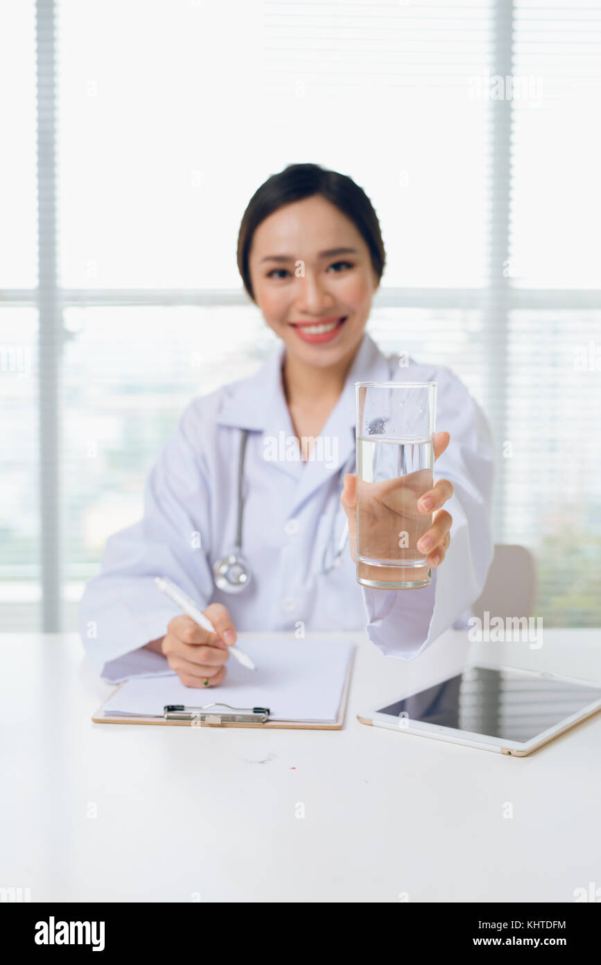 Asian attractive young woman doctor giving young glass of water Stock ...