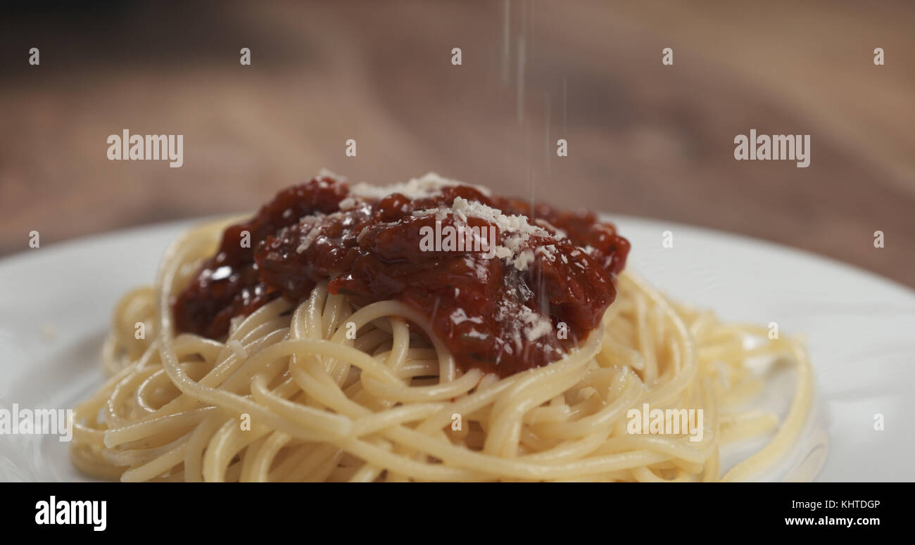 sprinkle grated aged parmesan cheese over spaghetti bolognese Stock ...