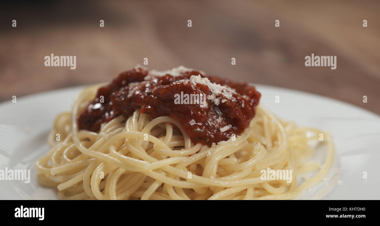 sprinkle grated aged parmesan cheese over spaghetti bolognese Stock ...