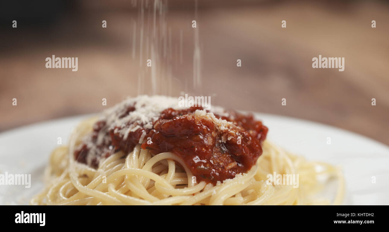 sprinkle grated aged parmesan cheese over spaghetti bolognese Stock ...
