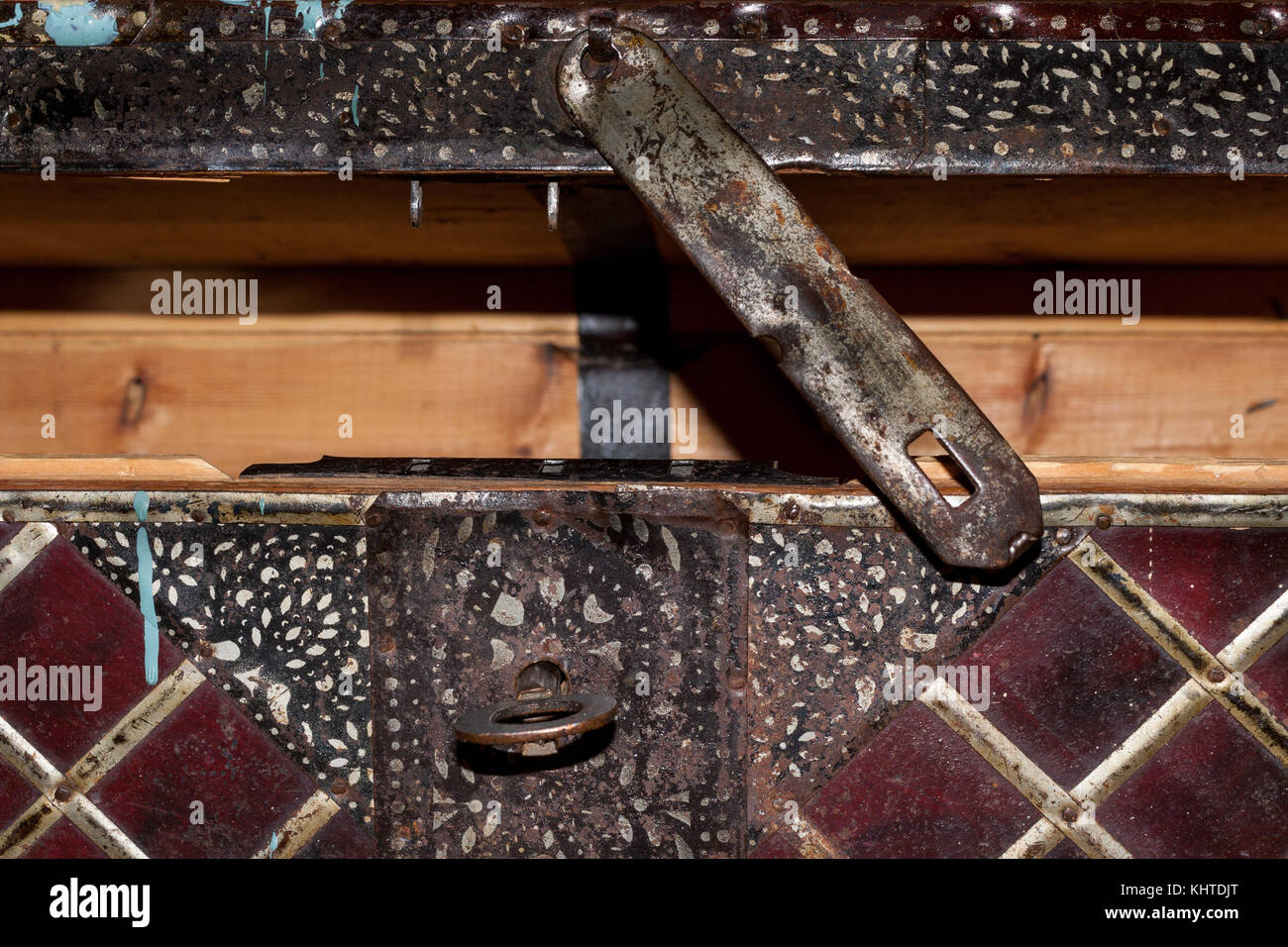 Part of semi-open big old wooden coffer, upholstered in painted wrought ...
