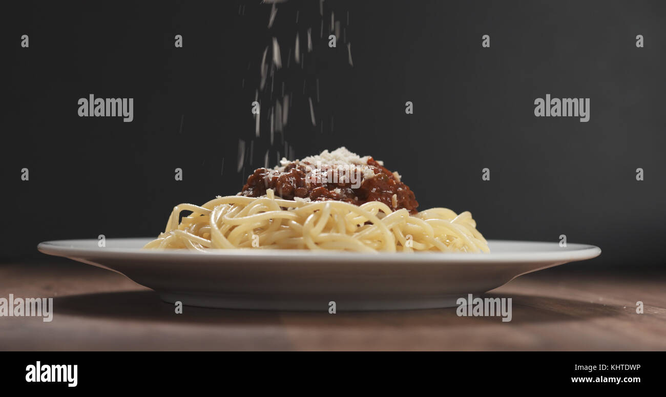 sprinkle grated aged parmesan cheese over spaghetti bolognese Stock ...