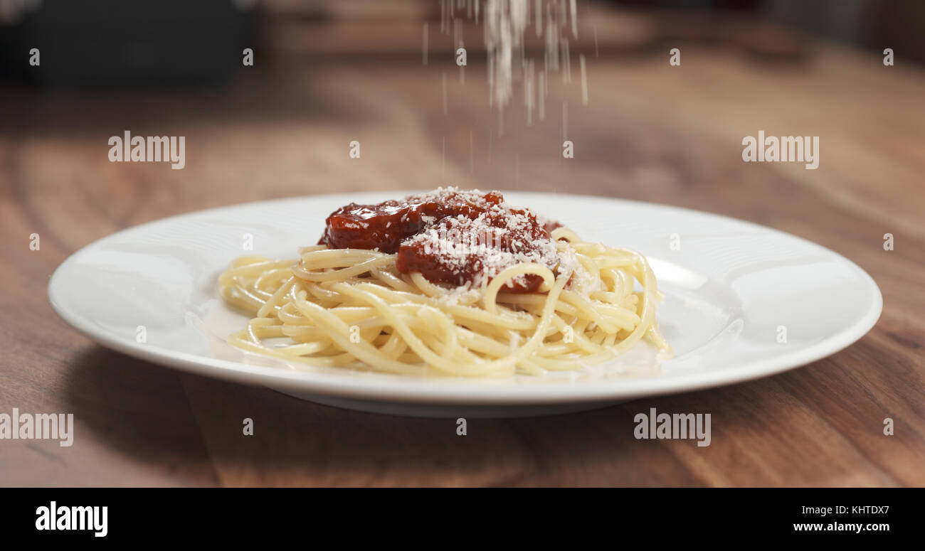 sprinkle grated aged parmesan cheese over spaghetti bolognese Stock ...