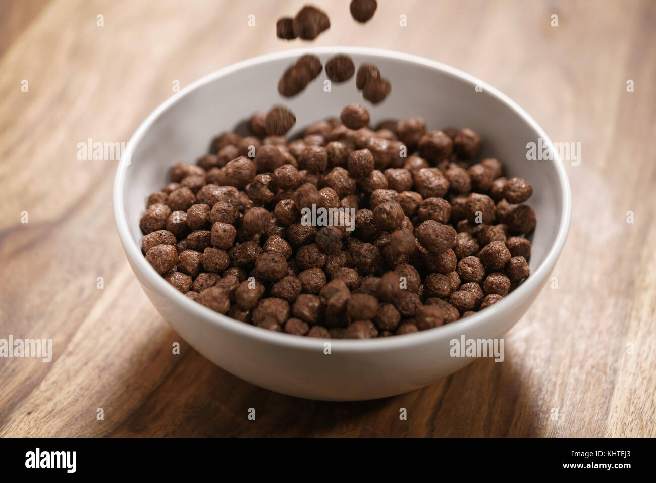 chocolate cereal balls fall in white bowl for breakfast Stock Photo - Alamy