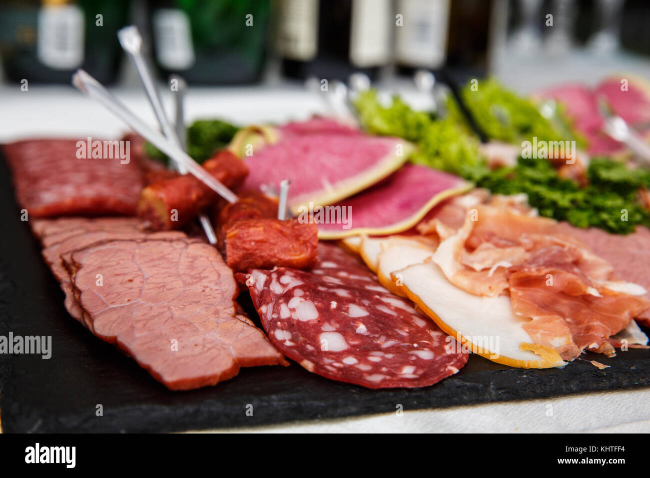 Food tray with delicious salami, pieces of sliced ham, sausage, salad ...