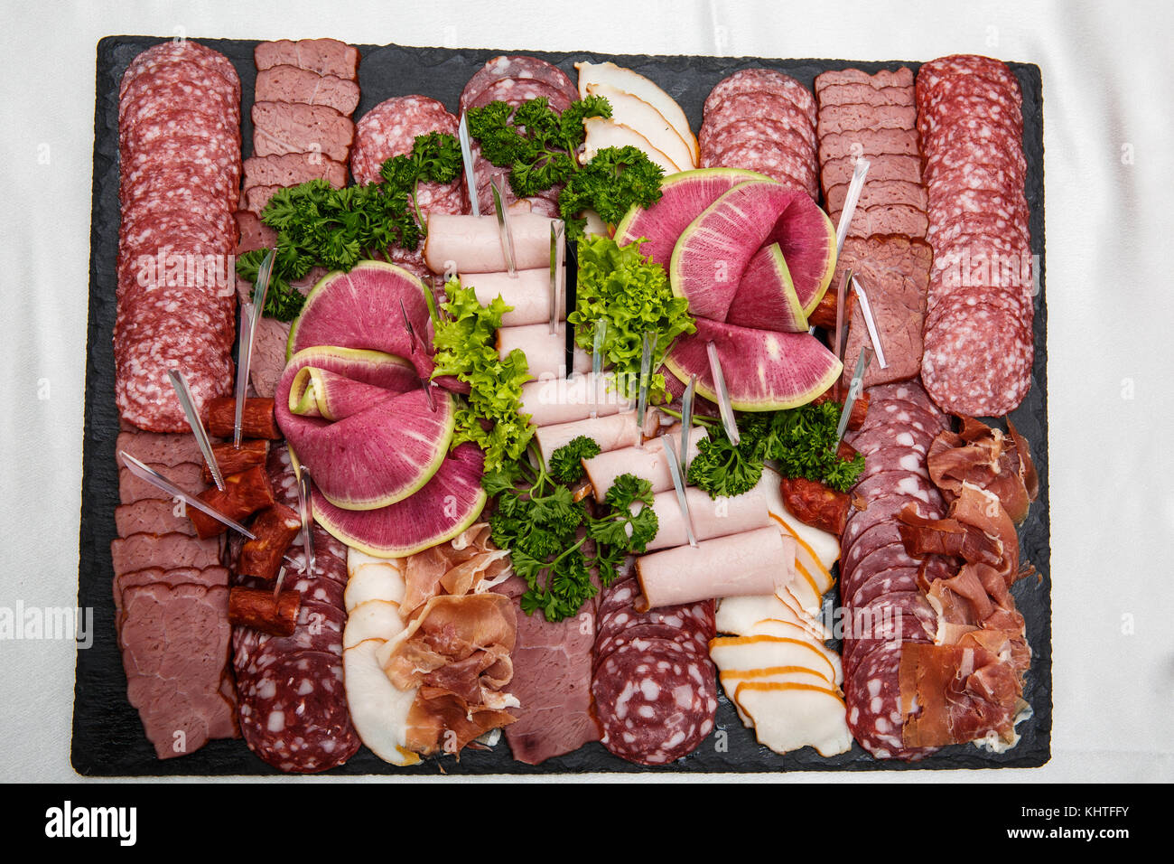 Food tray with delicious salami, pieces of sliced ham, sausage, salad ...
