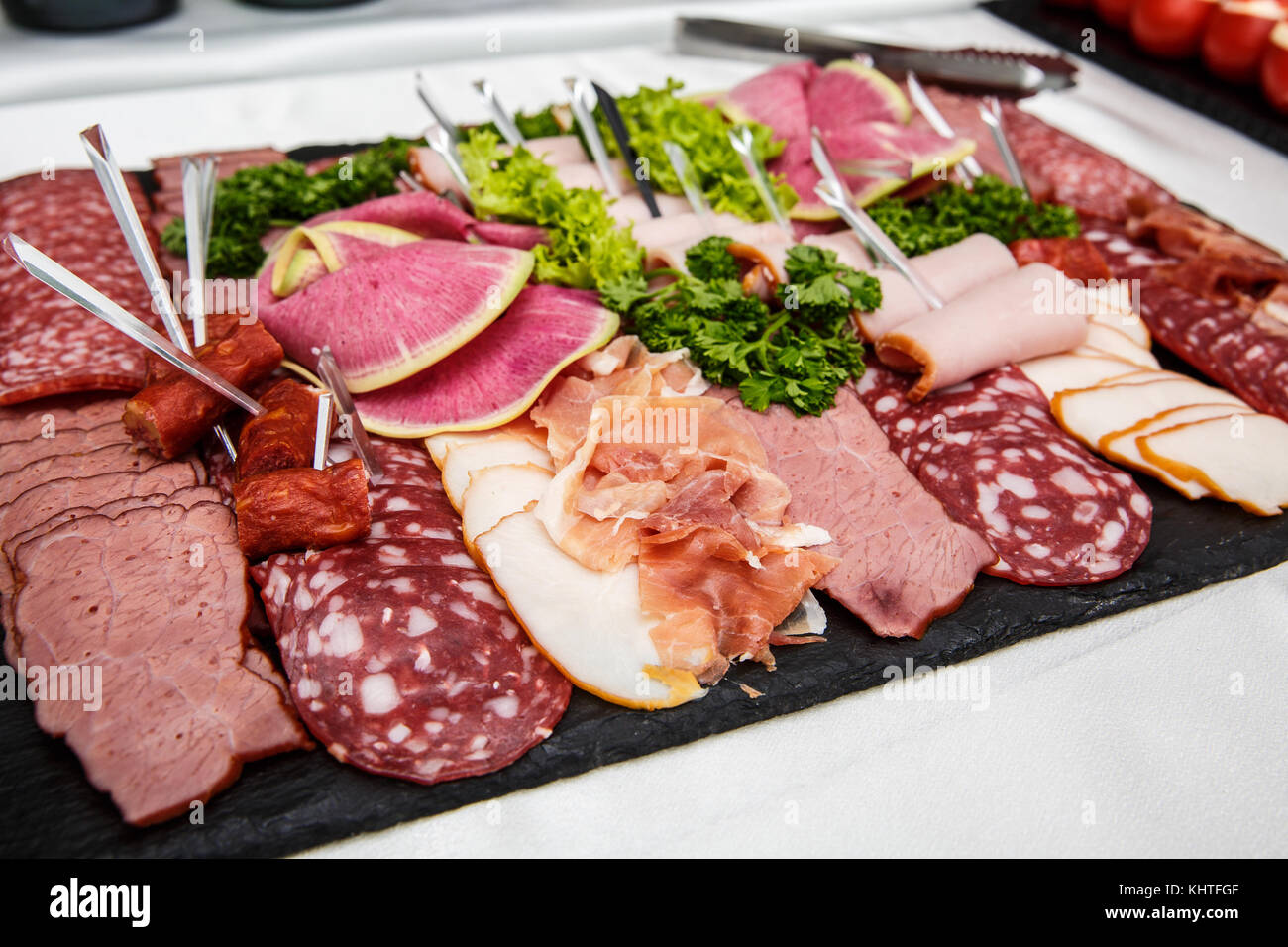 Food tray with delicious salami, pieces of sliced ham, sausage, salad ...