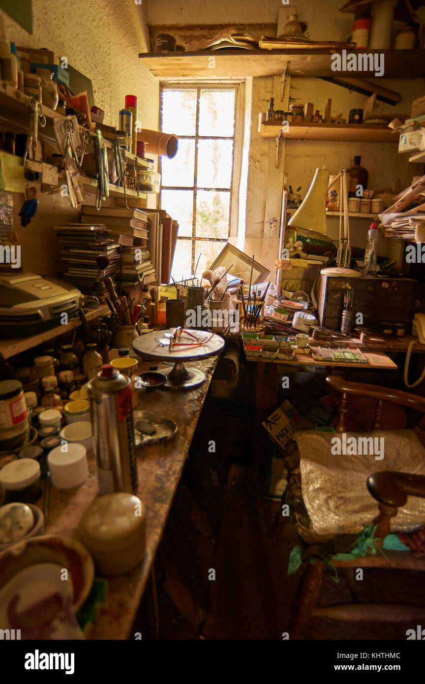 Cluttered shelves and work bench in pottery studio workshop ...