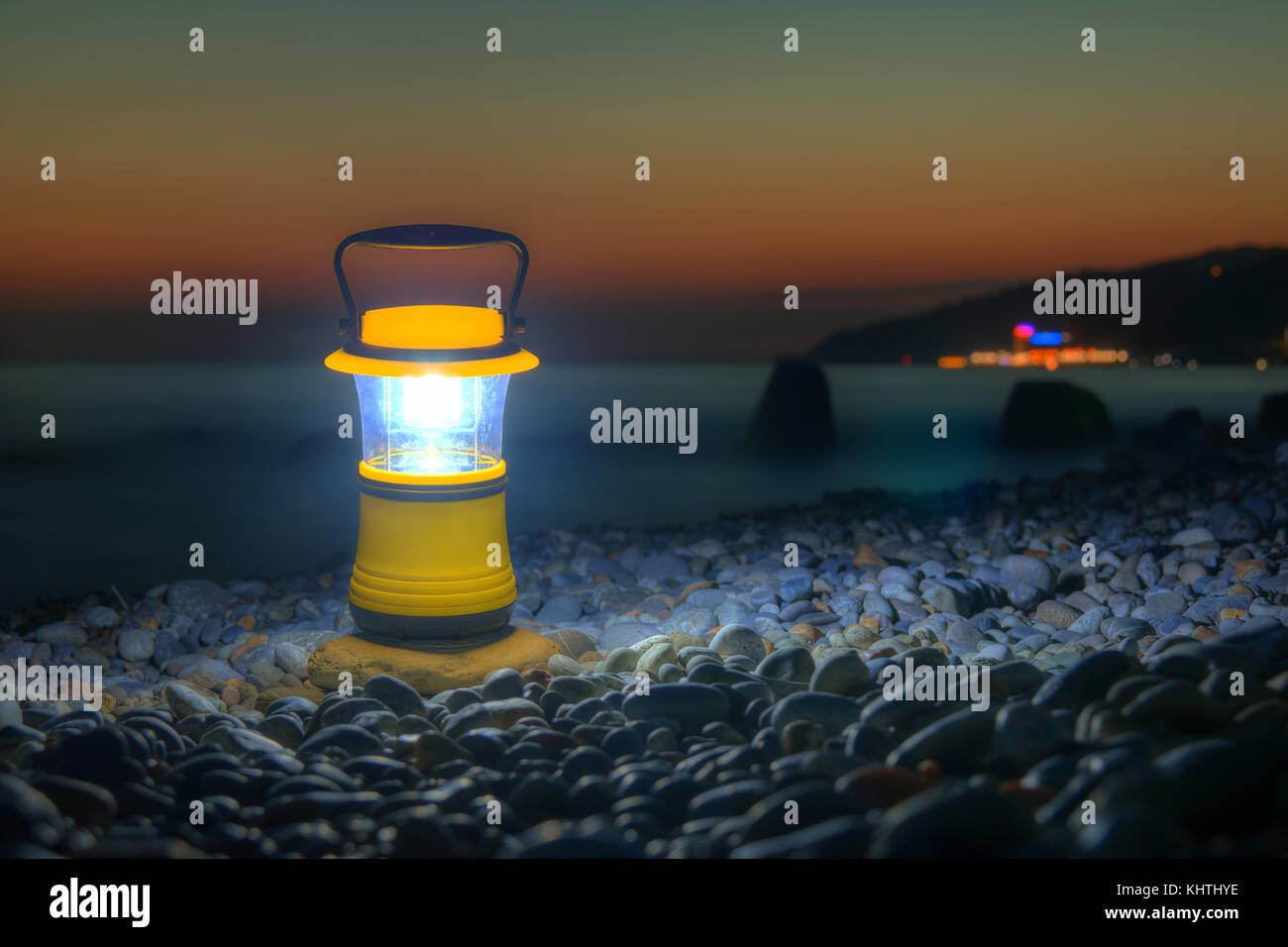 Luminous hand lantern standing on the pebble beach on the background of ...