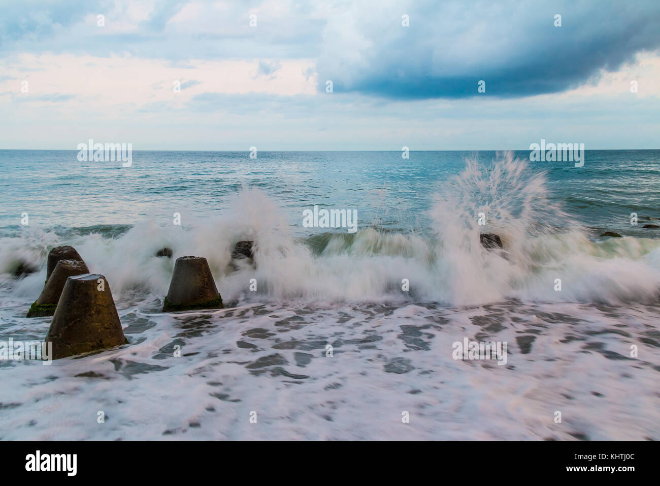 Seascape with the sea surf breaking on the concrete conical boulders ...