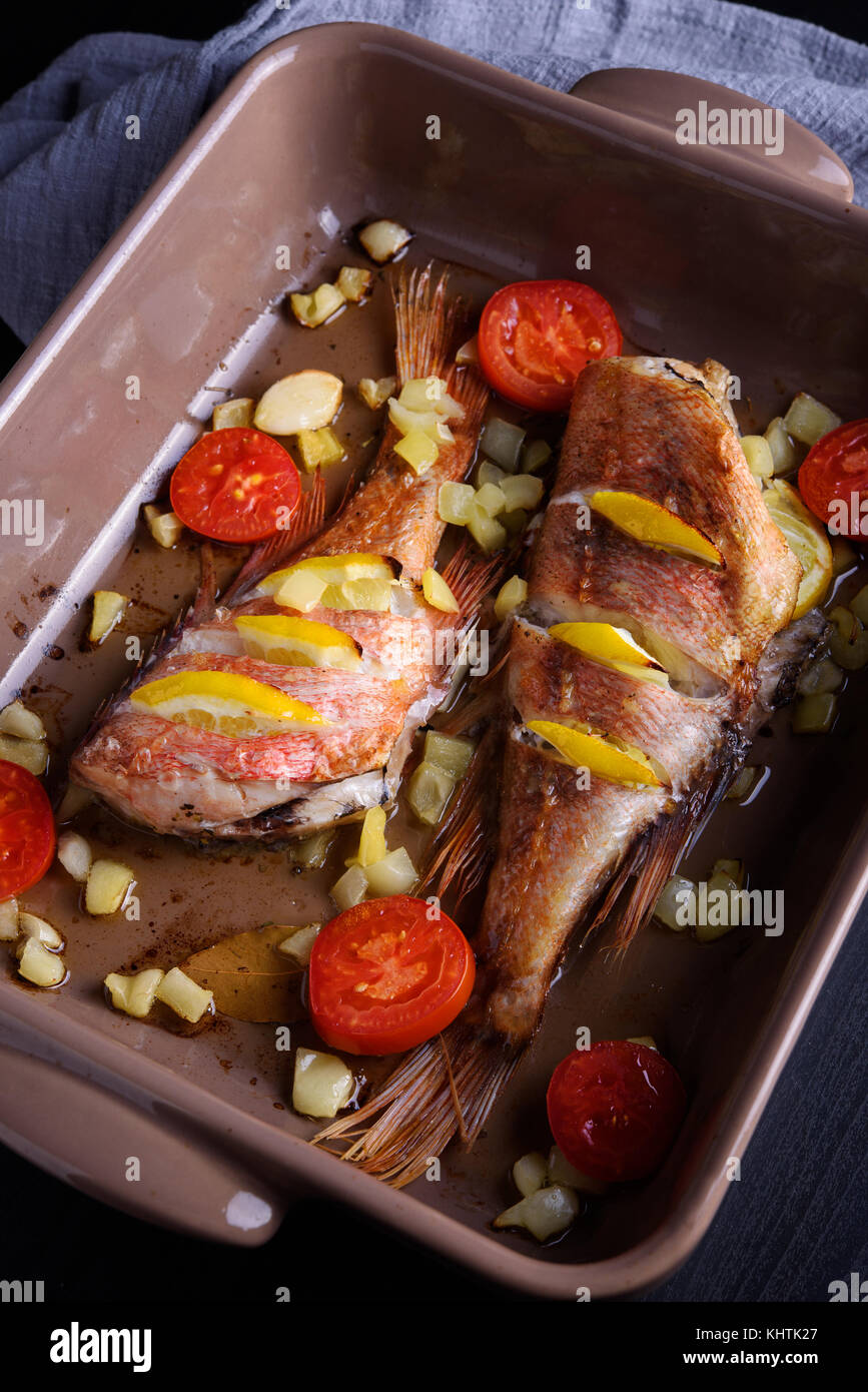 Red sea perch or red grouper with tomatoes and lemon baked and cooked ...
