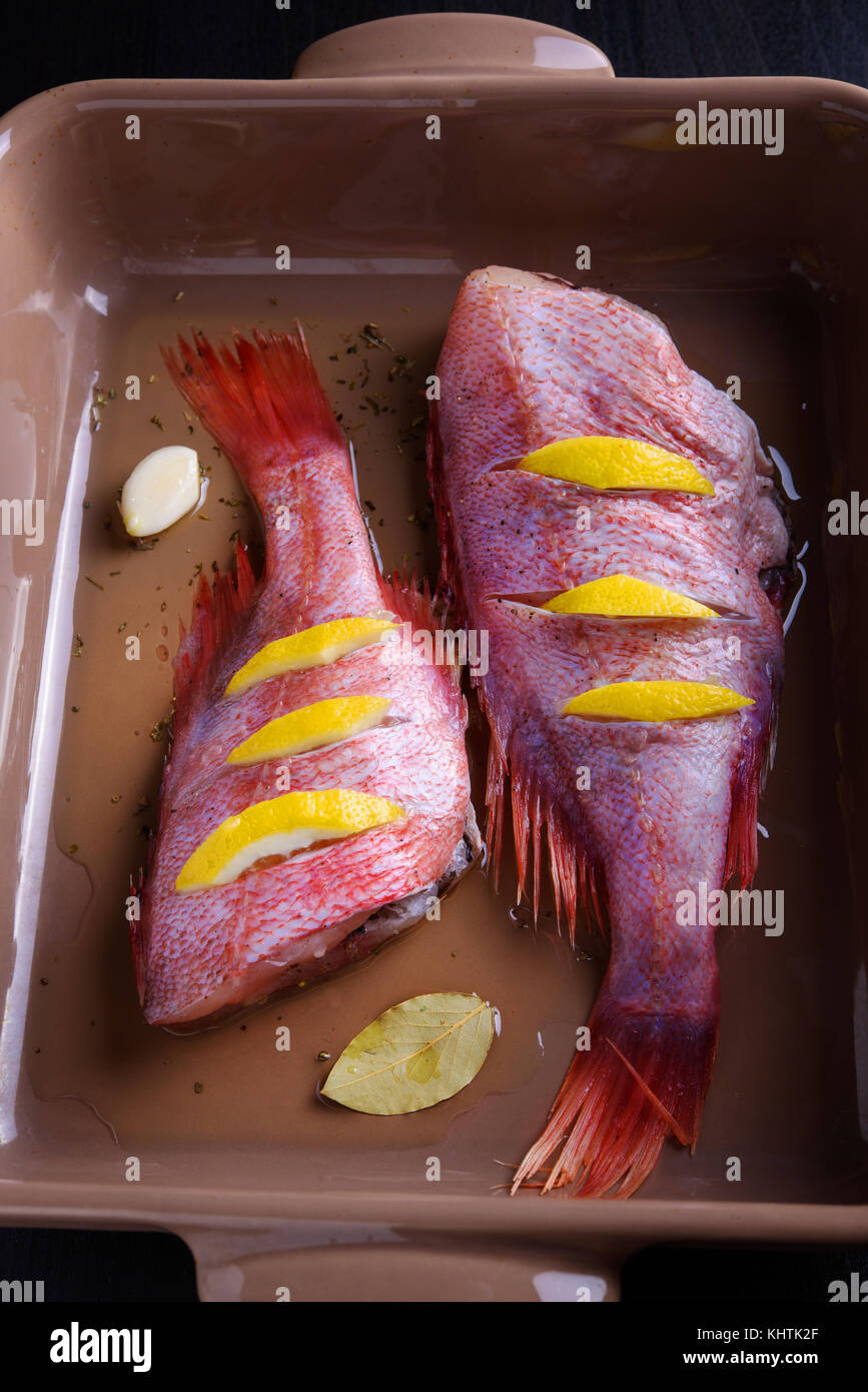Uncooked raw red sea perch or red grouper with lemon Stock Photo - Alamy