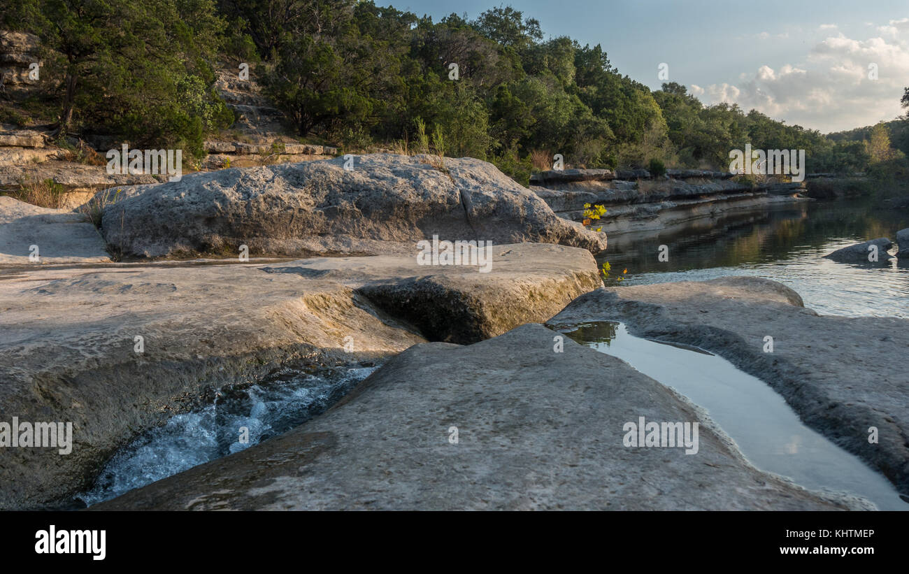 Water Flowing Through Rock Carvings With Calm Stream in the Background ...