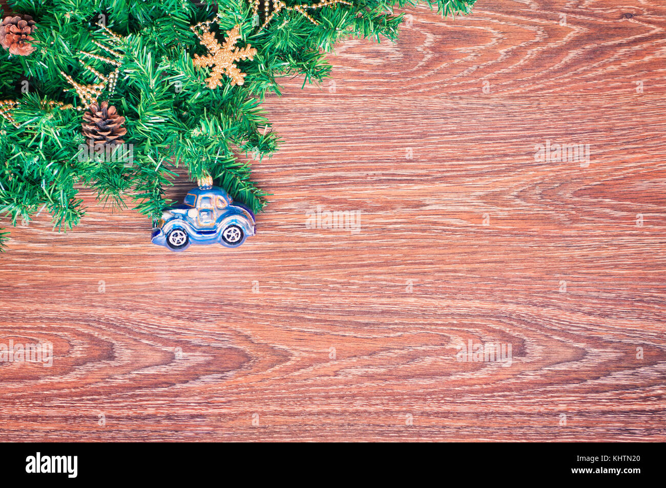 blue glass toy car hanging on fit tree branch against wooden background ...