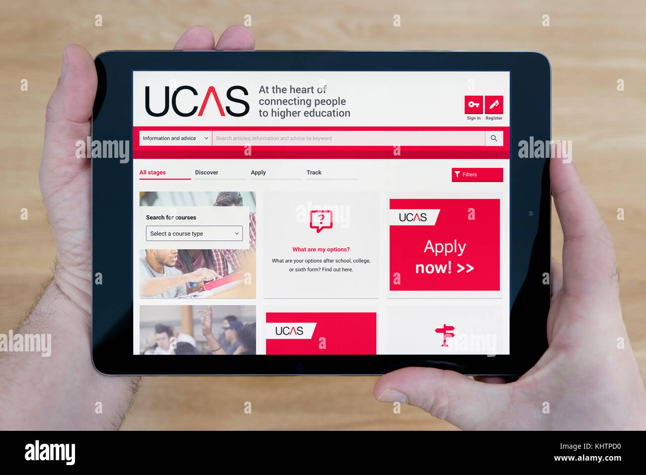 A man looks at the UCAS website on his iPad tablet device, shot against ...