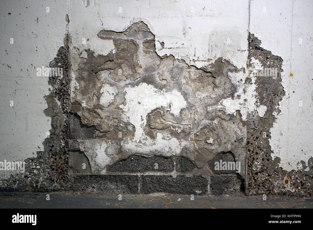 Crumbling plaster and exposed brickwork on a wall in my building's ...