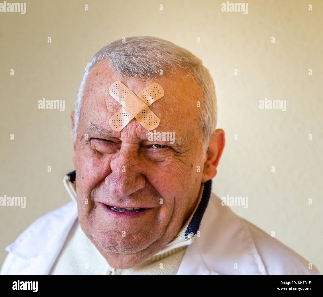 sad old doctor with patches on the forehead Stock Photo - Alamy