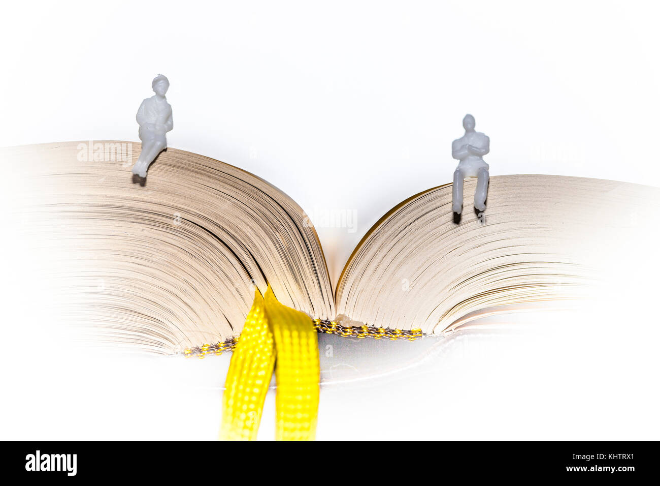 miniature people figures sitting on an open book Stock Photo - Alamy