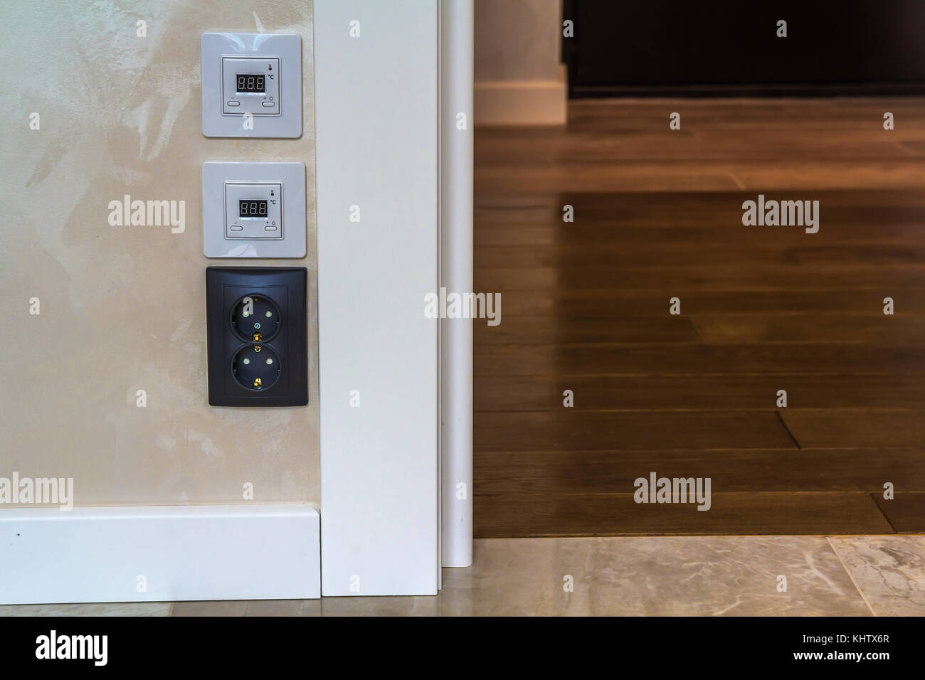 Electric socket and warm floor heater control panels on the wall in new ...