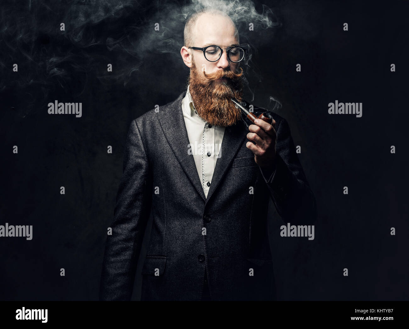 A man smoking pipe over grey background Stock Photo - Alamy