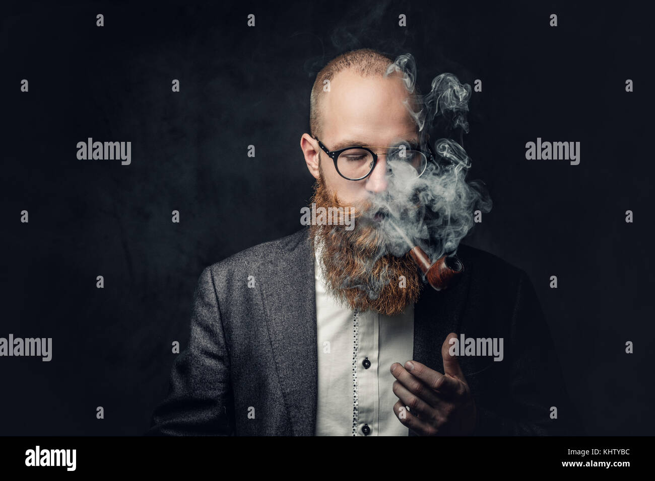 A man smoking pipe over grey background Stock Photo - Alamy