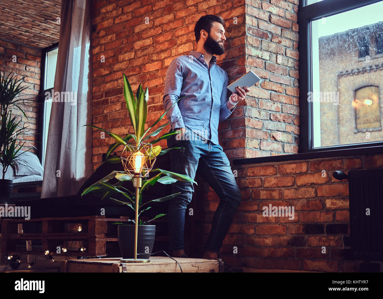 A man using tablet PC in a room Stock Photo - Alamy