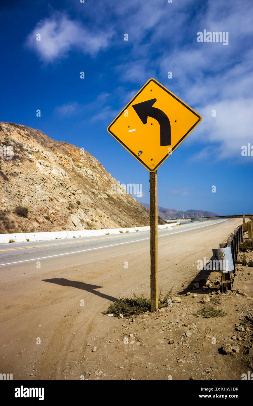 Yellow left turn sign along the winding Pacific Coast Highway, Southern ...