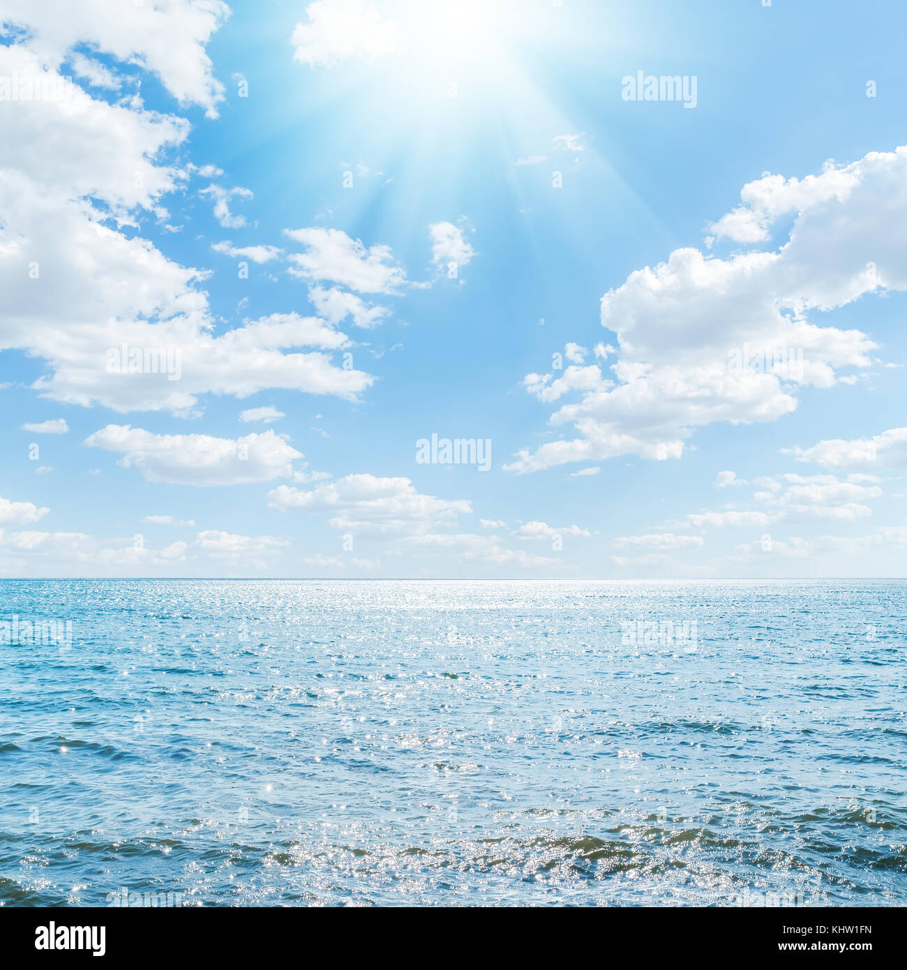 sun in clouds over blue sea Stock Photo - Alamy