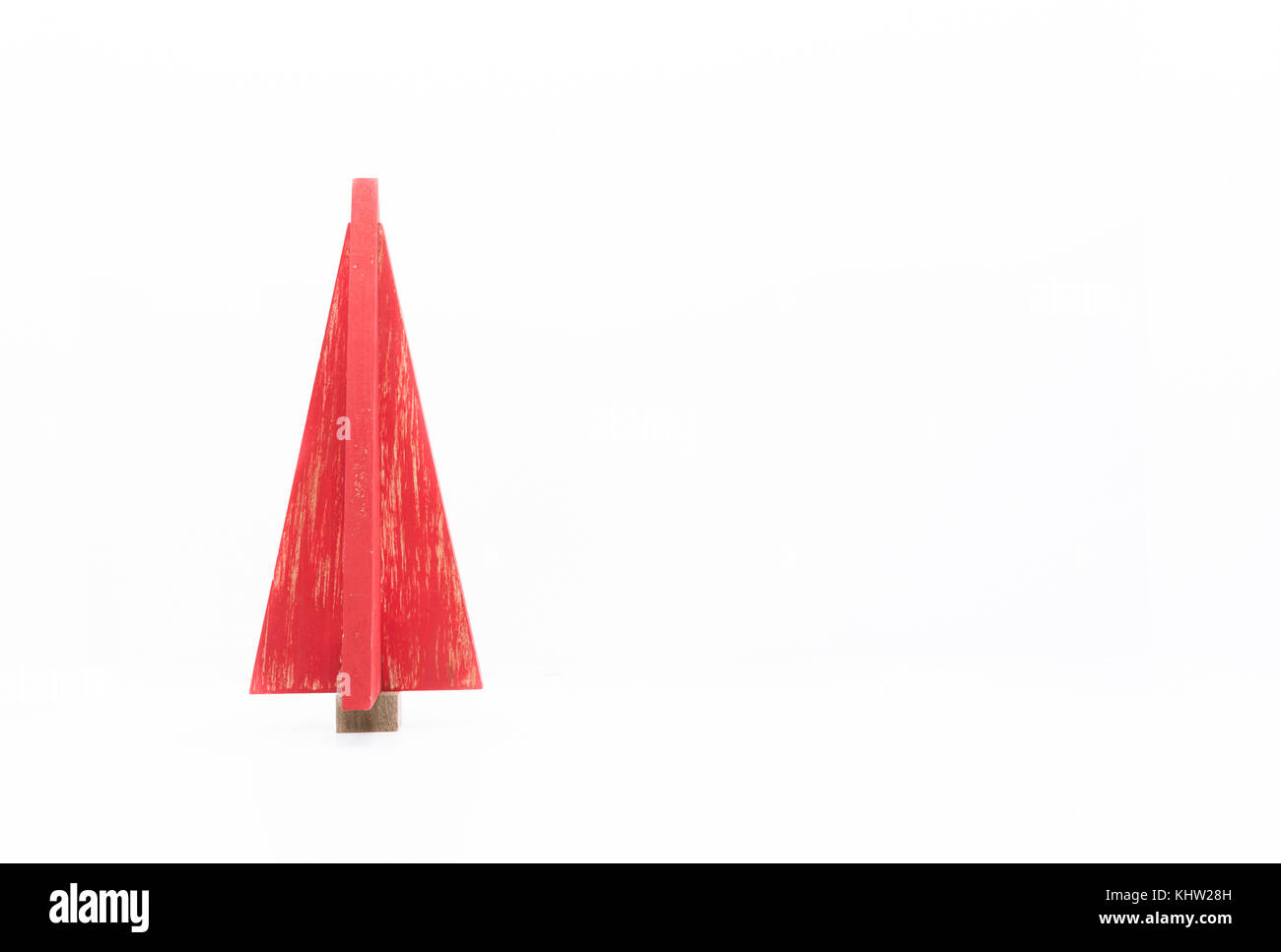 A stylized wooden red Christmas tree with distressed finish against a ...