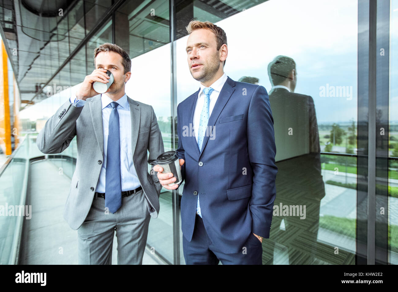 Business people having coffee break at the balcony of office building ...