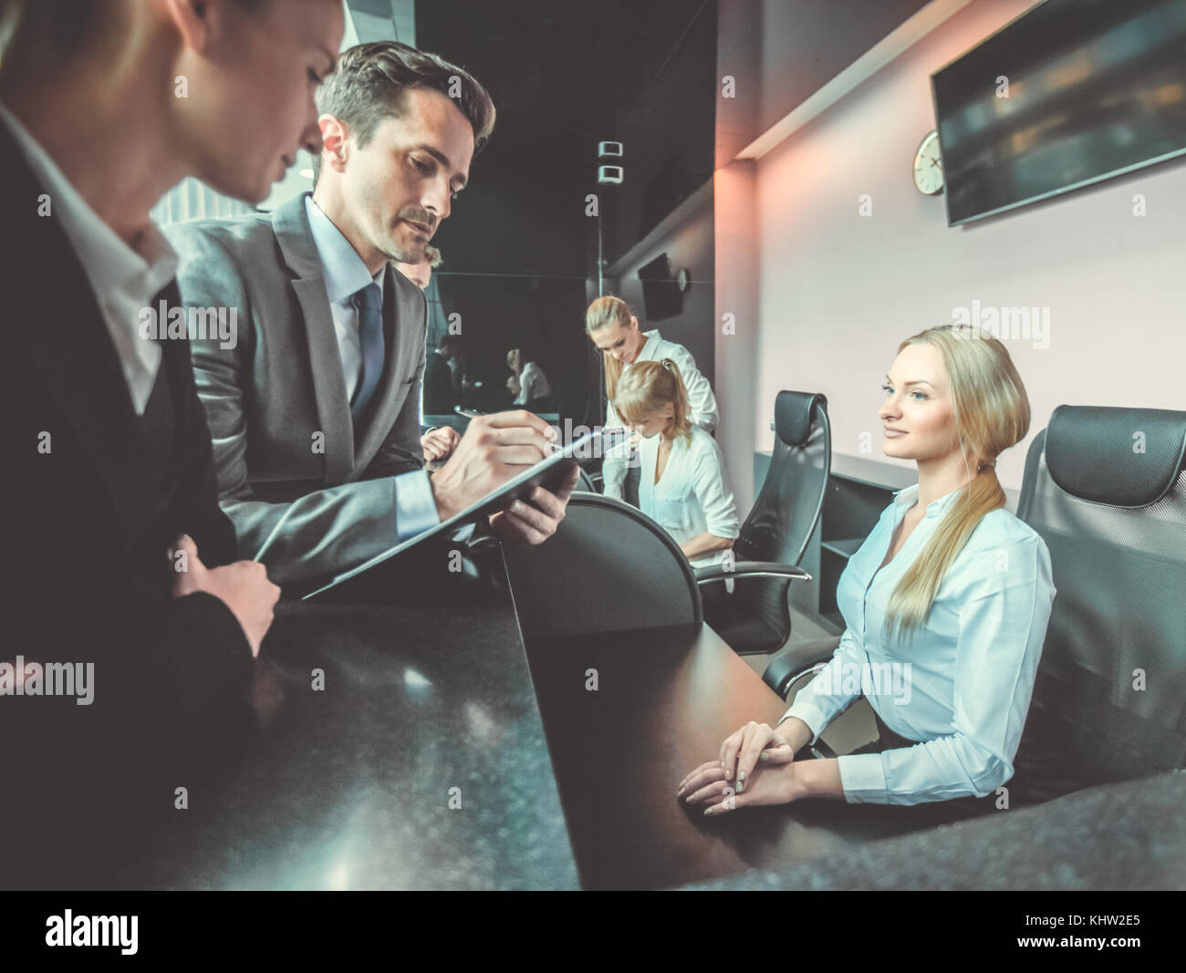 Business people filling forms at reception front desk Stock Photo - Alamy