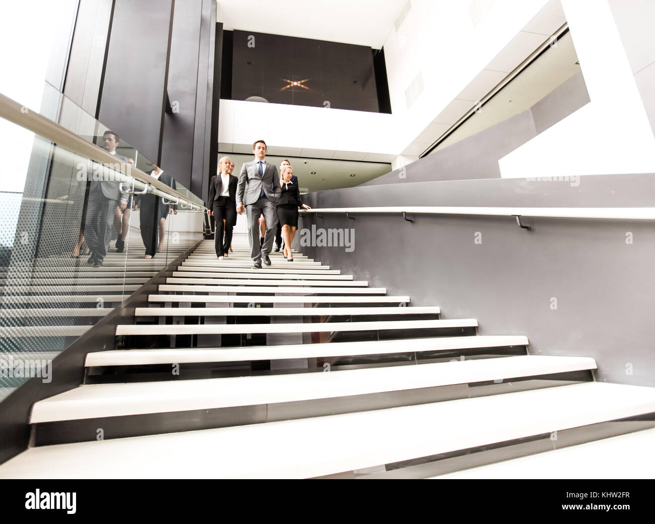 Group of business people walking and taking at stairs in an office ...