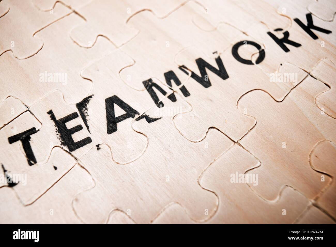 Teamwork word stamped on a wooden puzzle Stock Photo - Alamy
