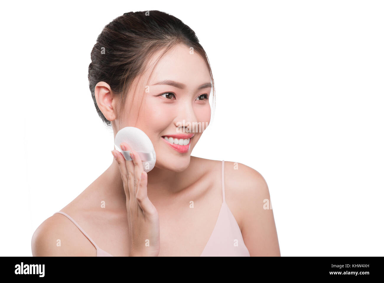 Portrait of beautiful young asian model applying some powder using ...