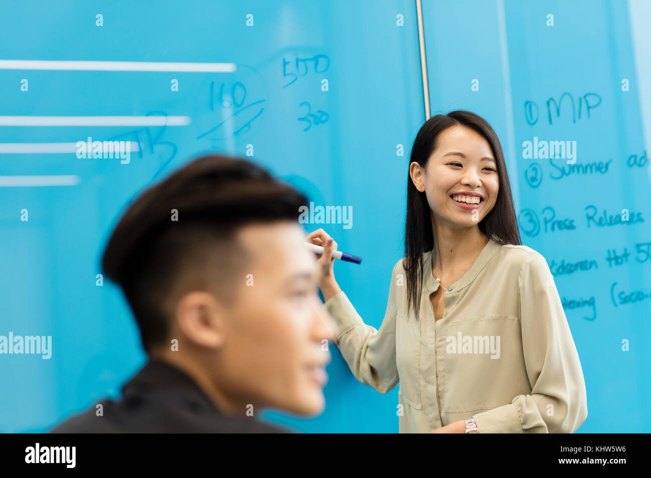 Woman writing on board Stock Photo - Alamy