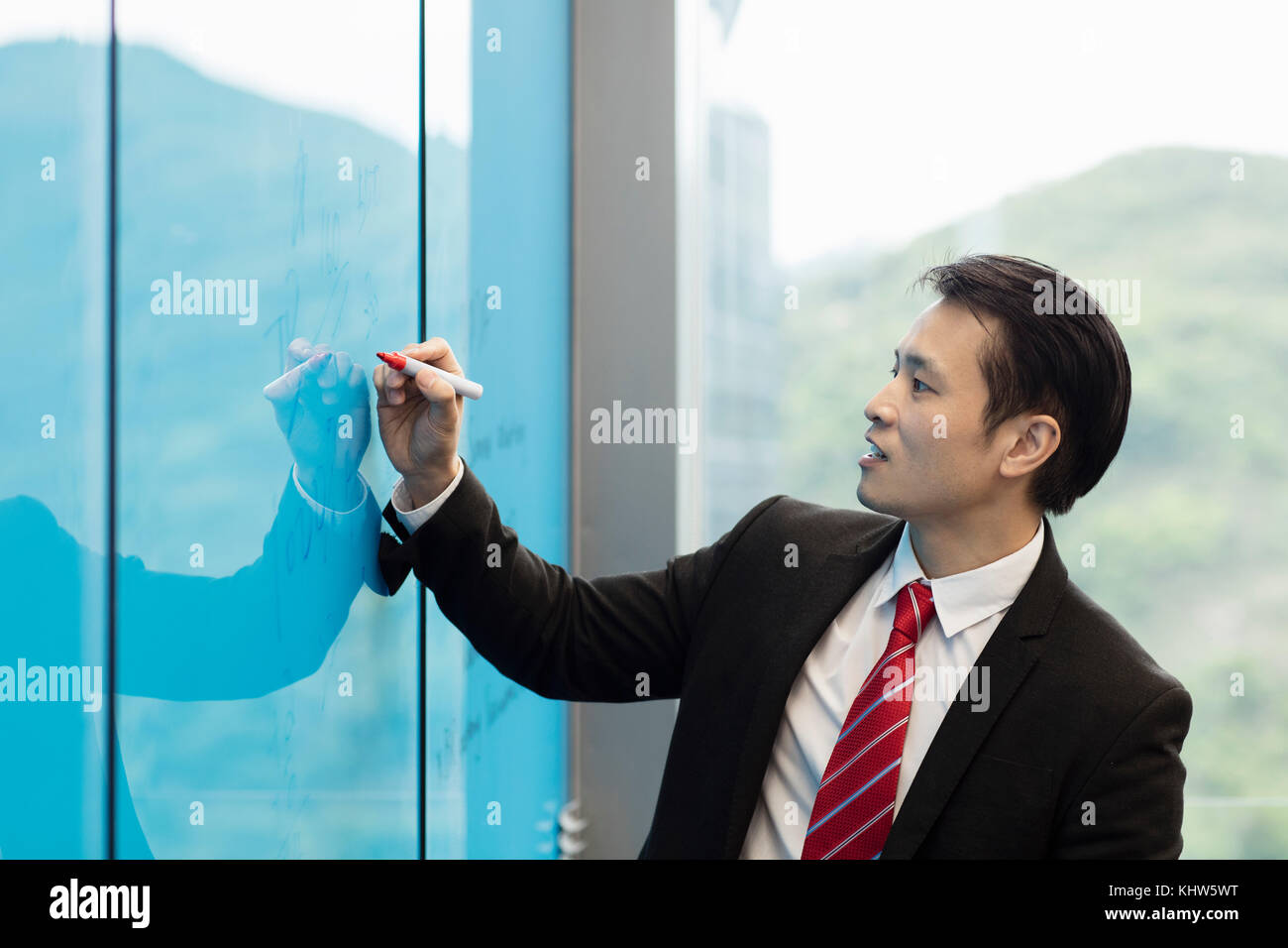 Man writing on board Stock Photo - Alamy